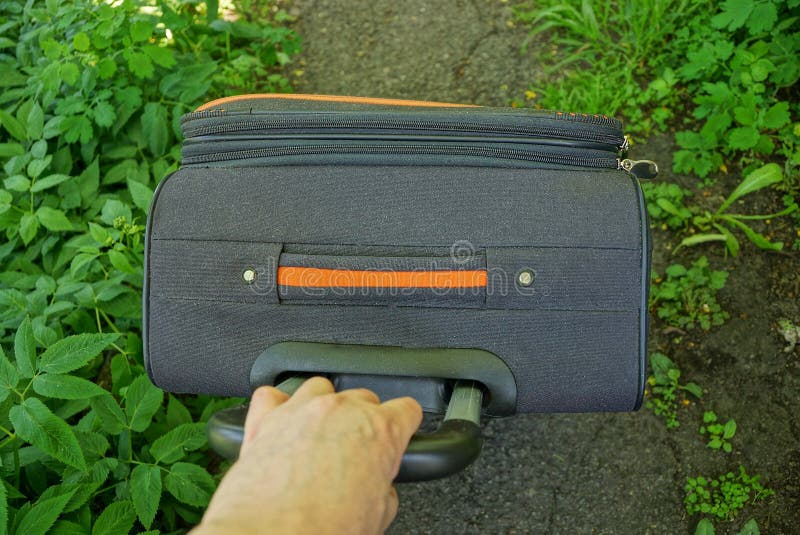 The Hand Pulls the Handle of a Large Suitcase on the Road Stock Image ...