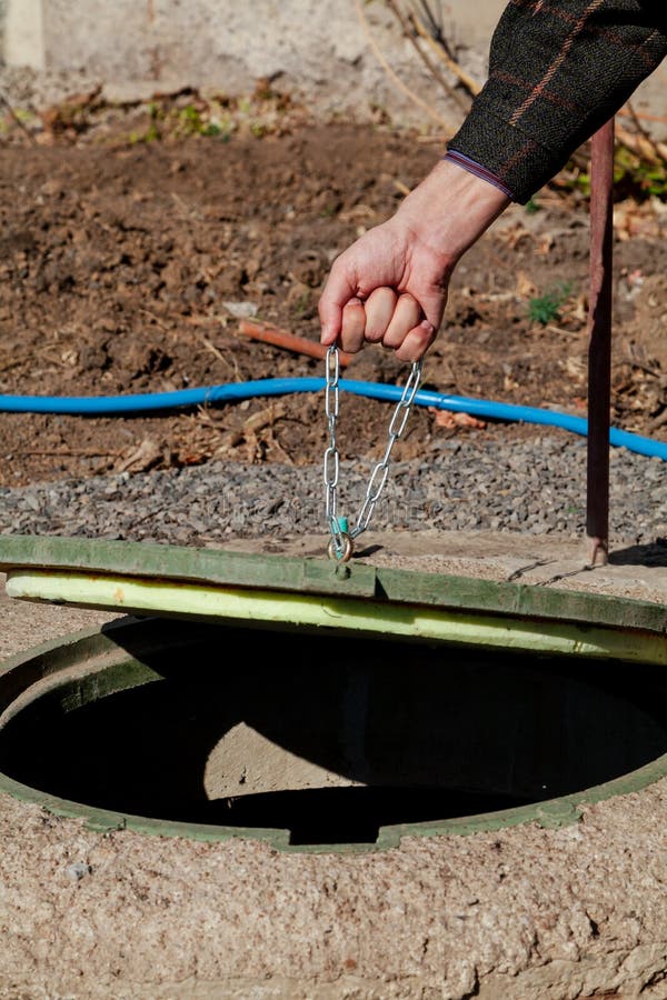 Hand Opens Sewer Hatch in Yard Stock Photo - Image of access, round ...