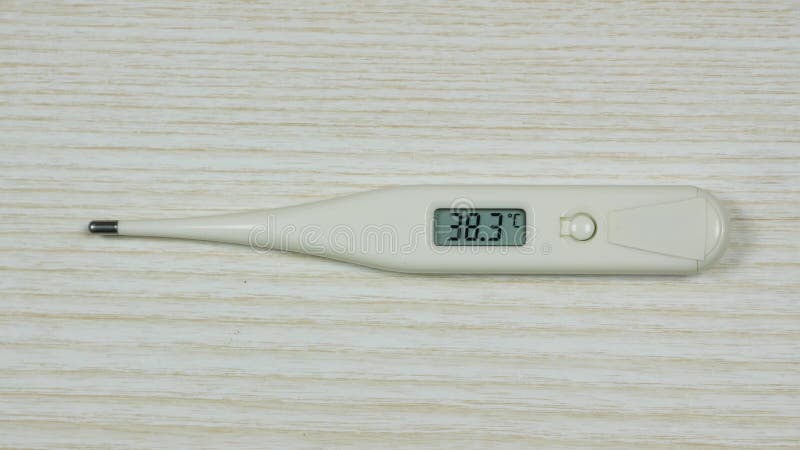 Hand Puts an Electronic Thermometer on the Table with a High ...