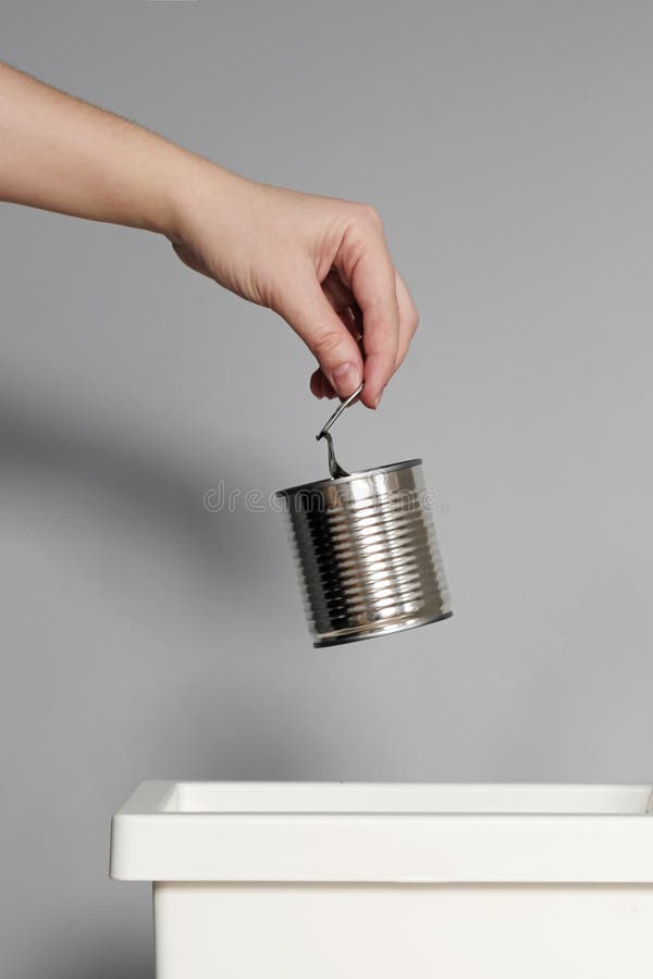 Hand Puts Empty Tin Can in the Trash Bin for Recycling. Stock Image ...
