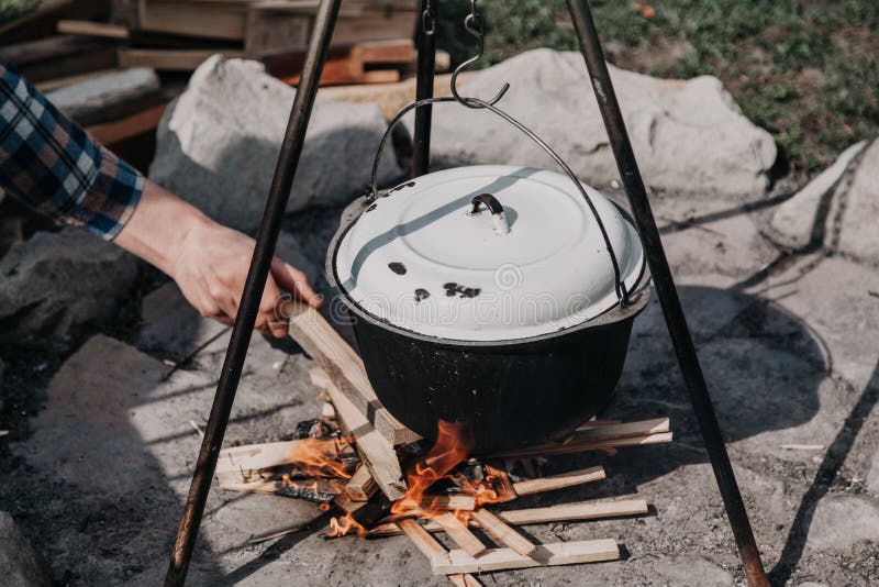 Hand Puts Log into Fire Under Pot Stock Image - Image of chain, close ...