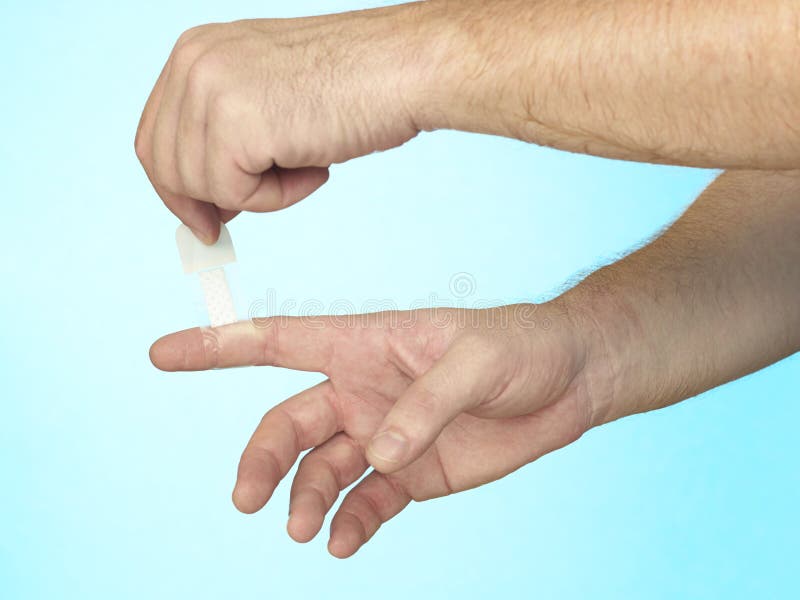 Hand Putting Adhesive Bandage on Man Finger. Stock Image - Image of ...