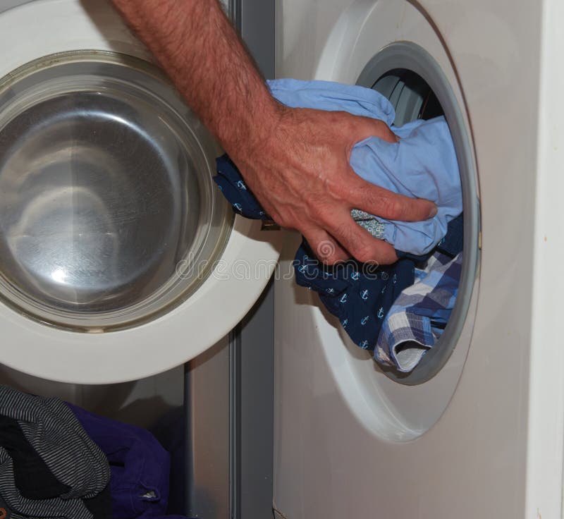 A Hand Putting Clothes into a Washing Machine Stock Image - Image of ...