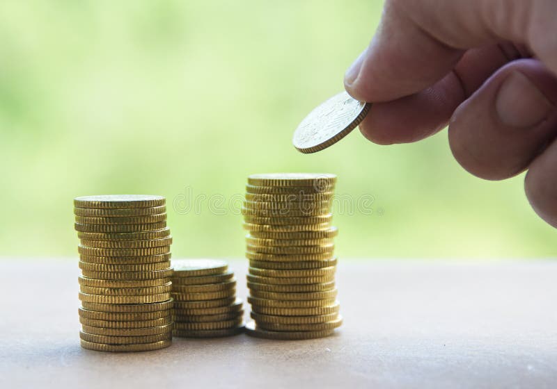 Hand Putting Golden Coin on a Stacking Coins. Wealth and Copy Space ...