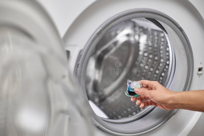 Hand Putting Laundry Detergent Capsule into Washing Machine Stock Image ...