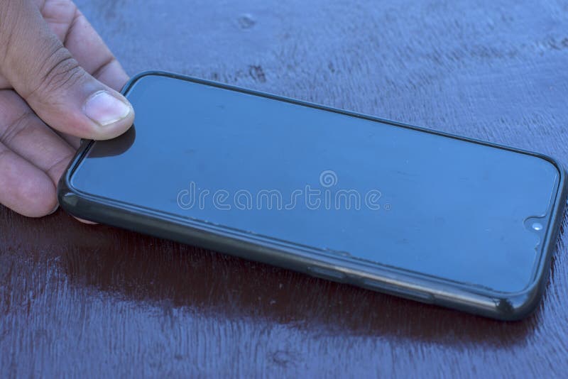 A Hand Putting a Mobile on Table Stock Image - Image of holding ...