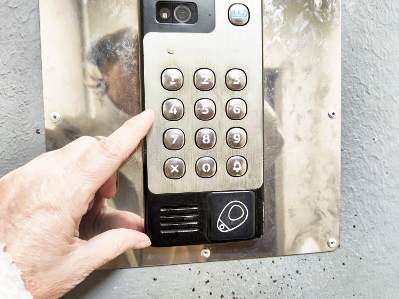 Person Pressing a Button on a Digital Intercom System Outside a ...