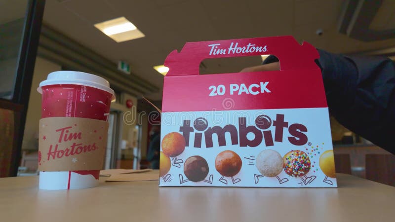 A Hand Reaches for a Timbit from a 20-pack Box at Tim Hortons in Slow ...