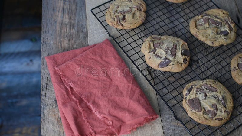 Hand Reaching for a Chocolate Chip Cookie Cooling on a Wire Rack on a ...