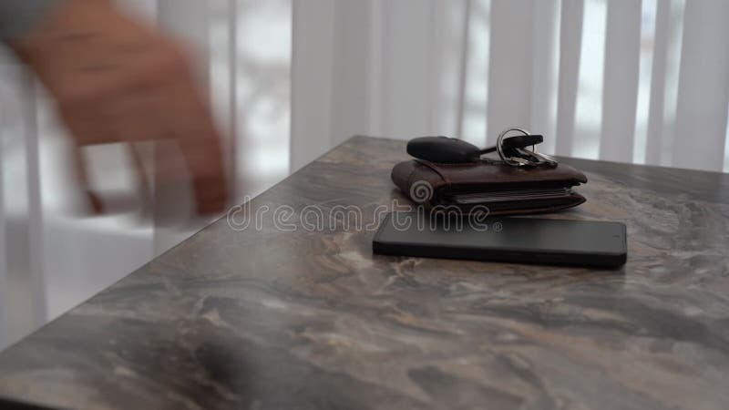 Hand Reaching for Smartphone and Keys on Table in Daylight Stock ...