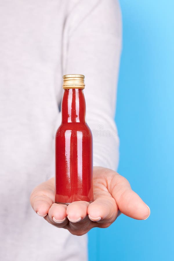 Hand with Red Hot Sauce in Bottle on Blue Background Stock Image ...