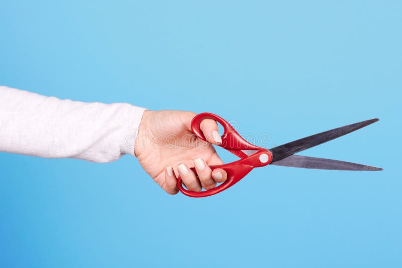 Hand with Red Scissors. Isolated on Blue Background Stock Photo - Image ...