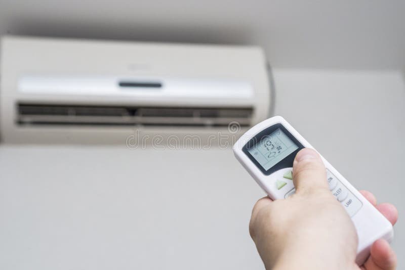 Hand with Remote Control Directed on the Conditioner on the Wall. Air ...