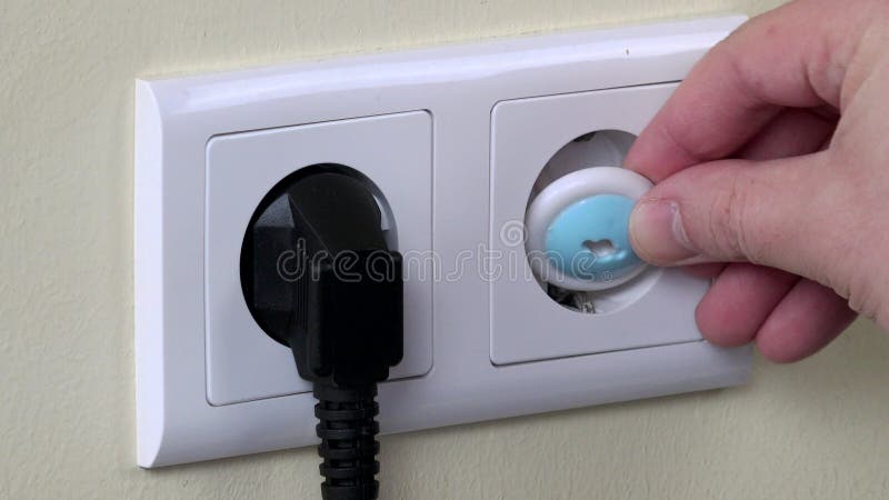 Man Hand Remove Plug Wire from Outlet and Insert Child Safety Plug ...