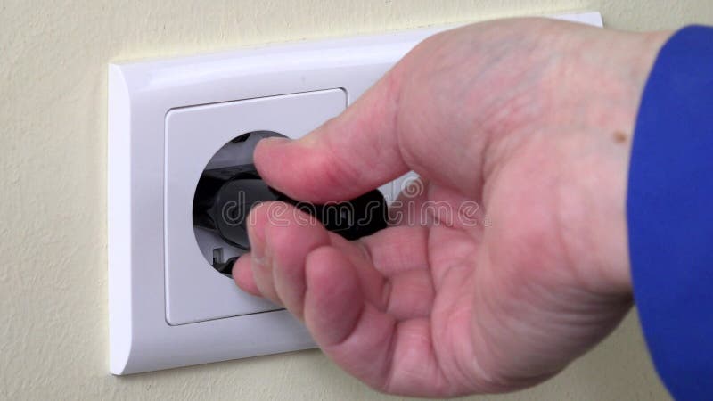 Hand Remove Safety Plug from Electricity Outlet and Insert Charger ...
