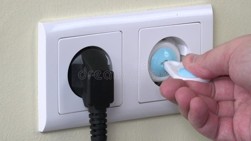 Man Hand Remove Plug Wire from Outlet and Insert Child Safety Plug ...