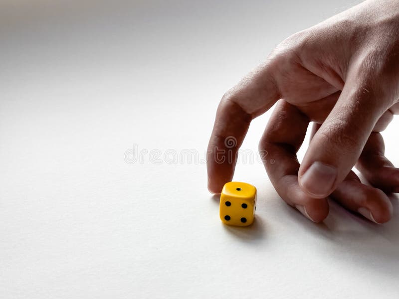 Hand Rolling Yellow Dice on White Surface for Luck and Strategy Stock ...
