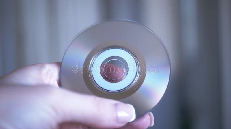 Hand rotating CD in light stock video. Video of glitter - 376424561