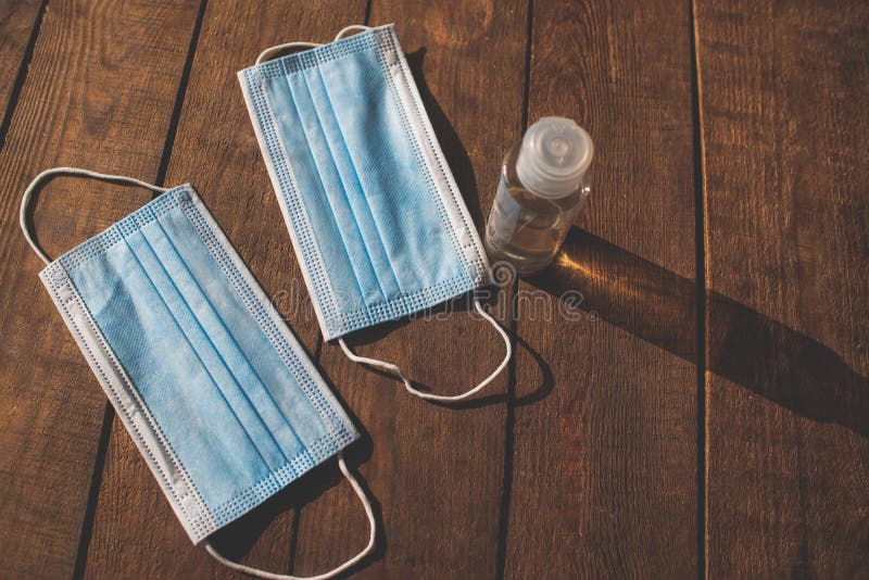 Hand Sanitizer and Disposable Masks Lie on a Wooden Table Stock Photo ...