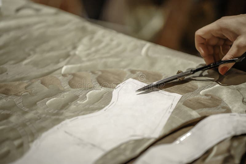 Hand with Scissors, Cutting Paper Pattern with Light Beige Fabric ...