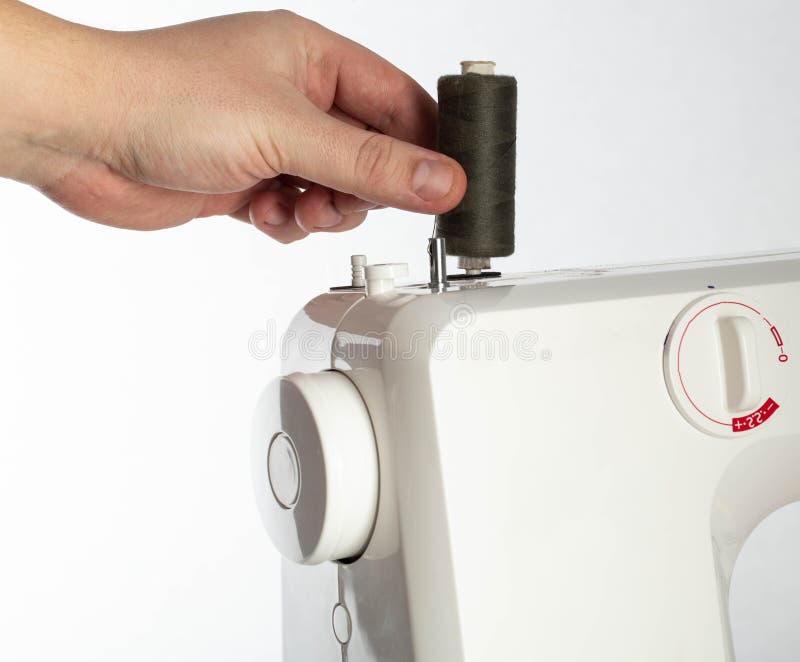 Hand of a Seamstress Putting a Spool of Thread on a Sewing Machine ...
