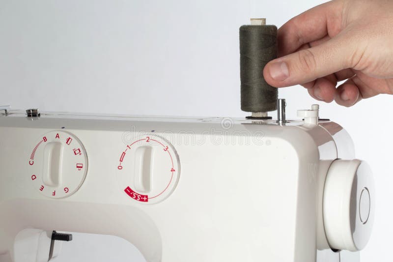 Hand of a Seamstress Putting a Spool of Thread on a Sewing Machine ...