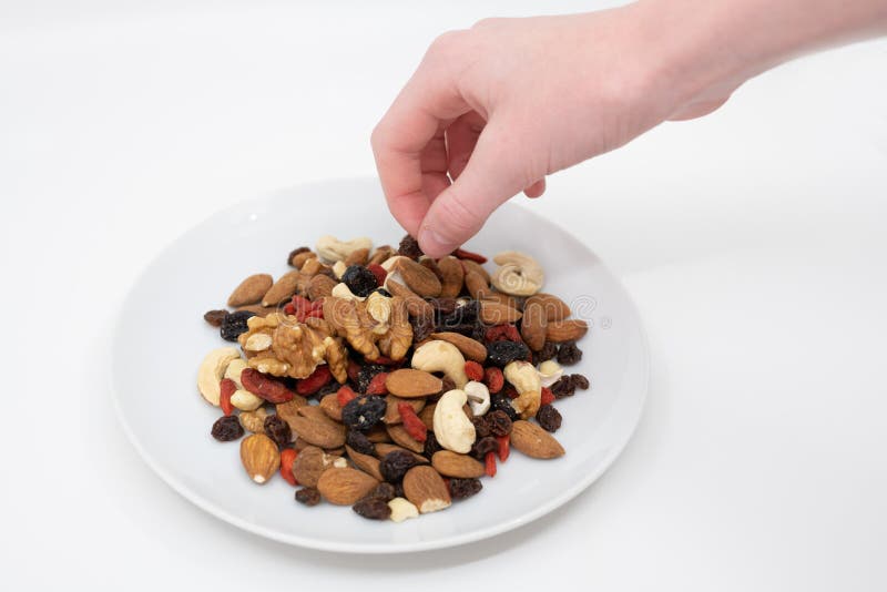 Hand Selecting from a Plate of Mixed Fruit and Nuts Stock Image - Image ...