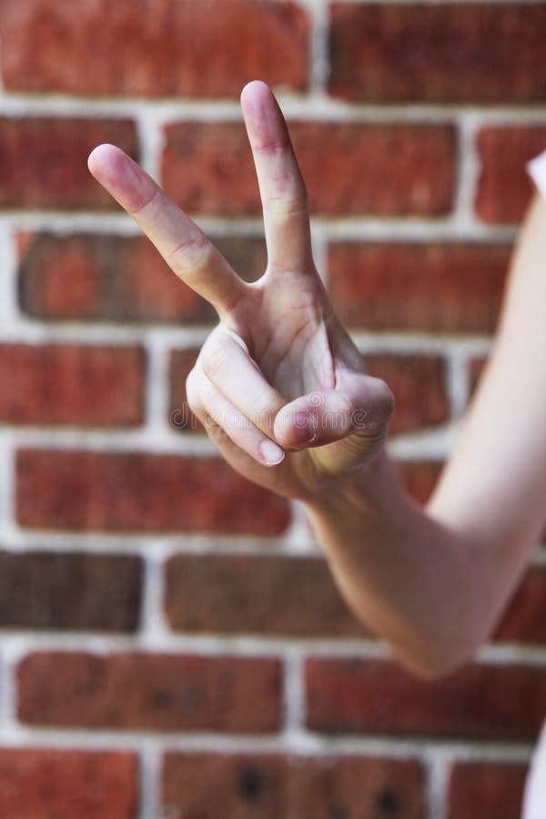 Hand Showing Peace Sign Against a Brick Wall Stock Photo - Image of ...