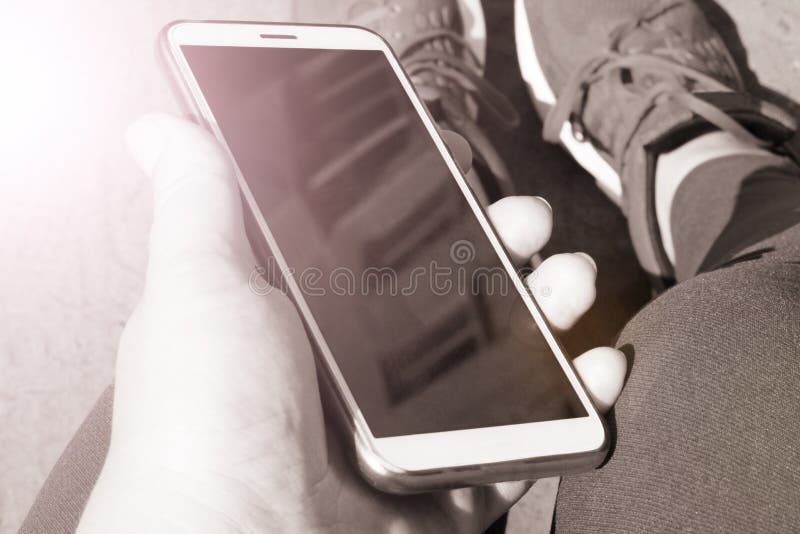 Hand with a Smartphone on the Background of Feet and Red Sneakers Stock ...
