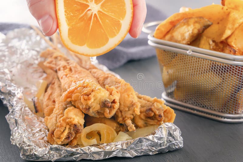 Hand Squeezes Lemon Juice into Fish Baked in Foil. Stock Photo - Image ...