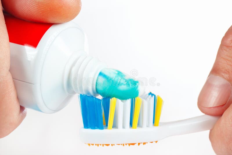 Hand Squeezes the Toothpaste on the Toothbrush on White Background ...
