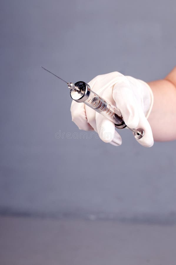 Hand Squeezing an Old Glass Syringe with a Sharp Needle. Stock Photo ...