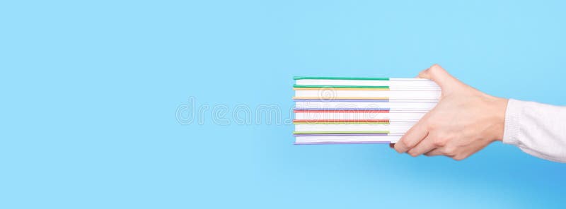 Hand with Stack of Books on Blue Background Stock Image - Image of ...