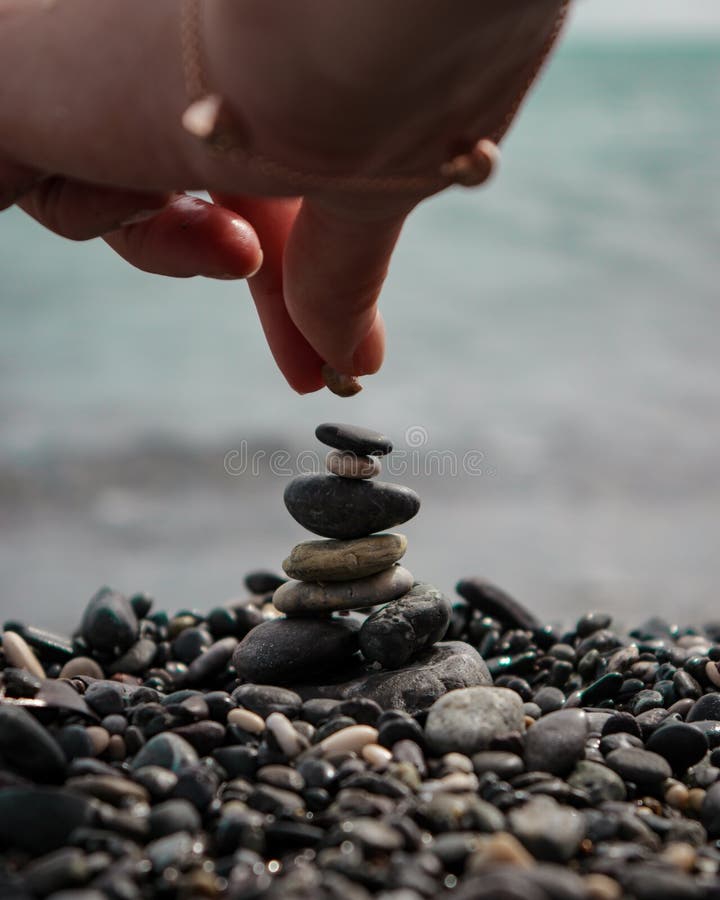 Hand Stacking Pebbles on Top of Each Other Stock Photo - Image of ...
