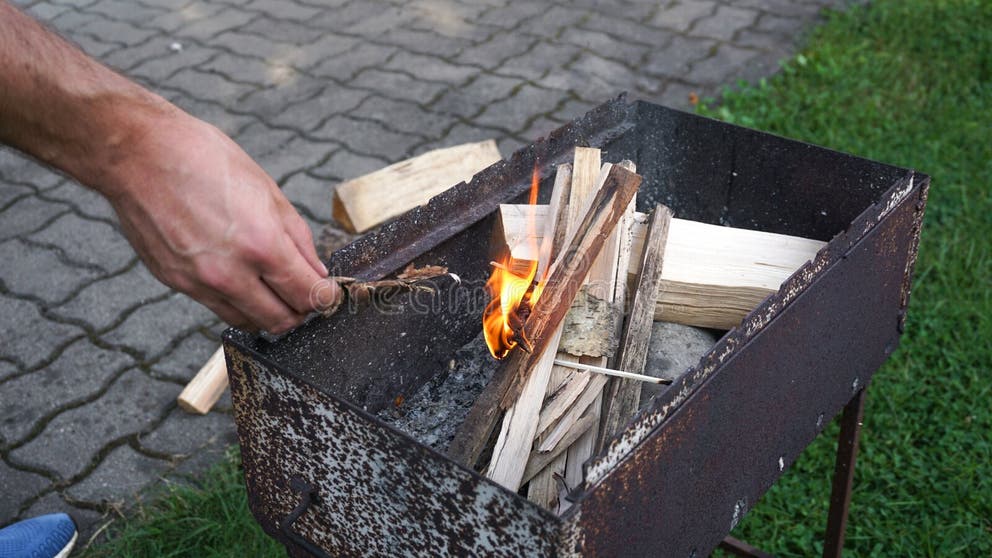 A Hand is Starting a Fire in a Grill for Barbeque Stock Image - Image ...