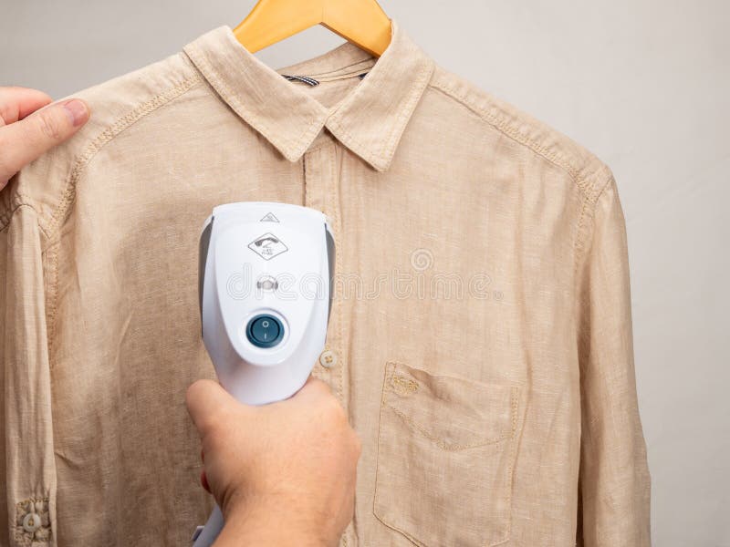 In Hand Steamer for Clothes. a Shirt is Ironed with a Portable Iron ...