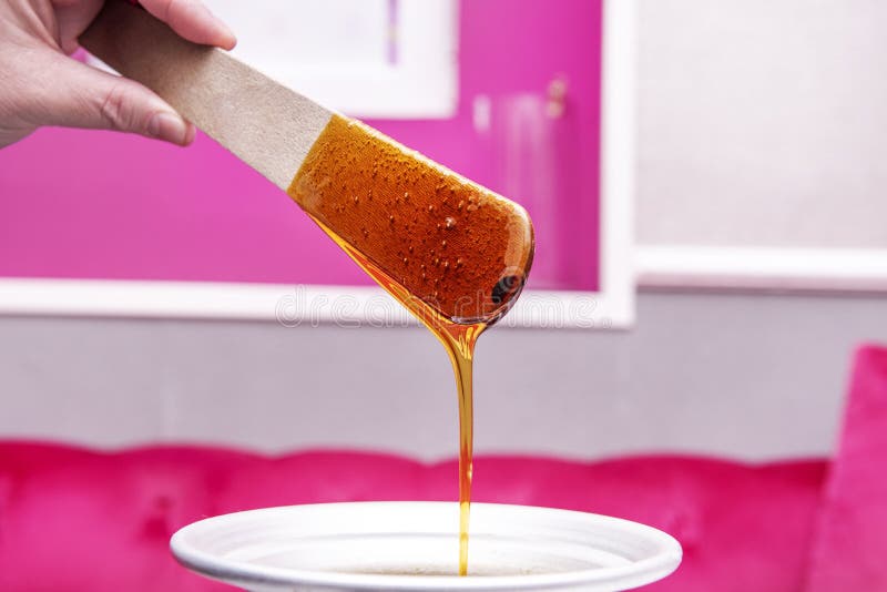 A Hand Stretching Hot Wax with a Wooden Stick Stock Photo - Image of ...