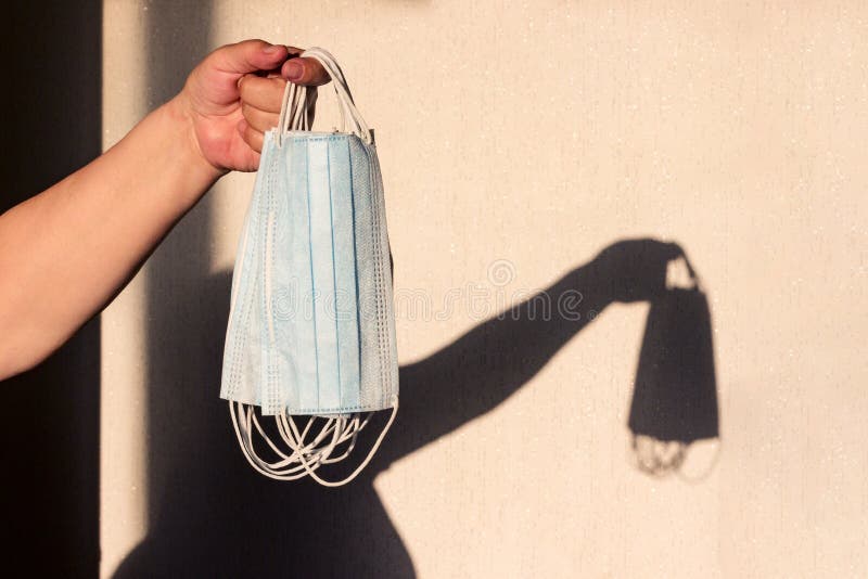 Hand with a Surgical Face Mask with Shadow, Concept Failed or Operation ...