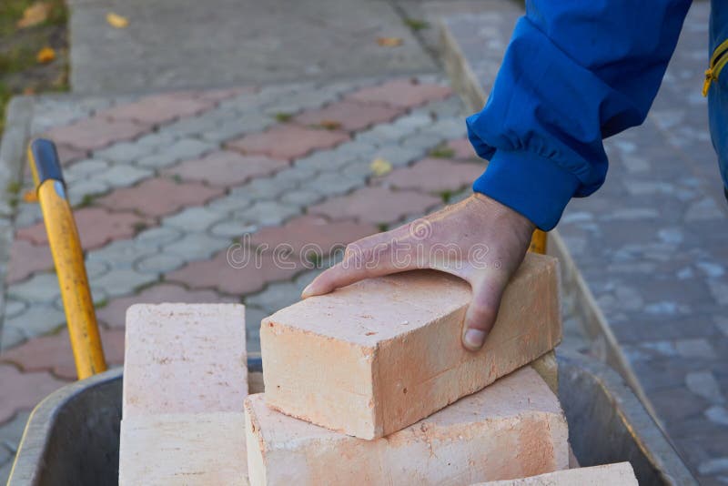 Hand Takes a Brick,builder Takes a Brick by Hand from a Wheelbarrow ...