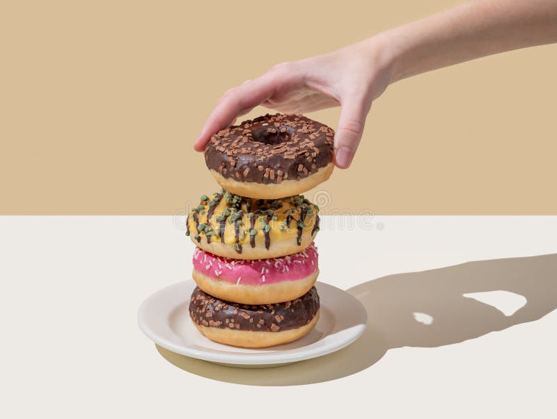 Hand Takes One Donut from Stack of Glazed Donuts with Different ...