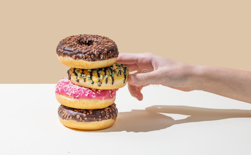 Hand Takes One Donut from Stack of Glazed Donuts with Different ...