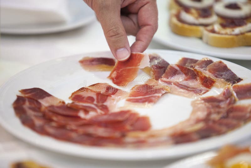 Hand Taking Iberian Cured Ham Slice from Plate Stock Photo - Image of ...