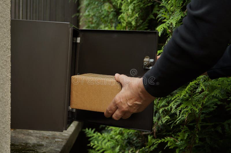Hand Taking a Large Package in Mailbox Stock Photo - Image of green ...