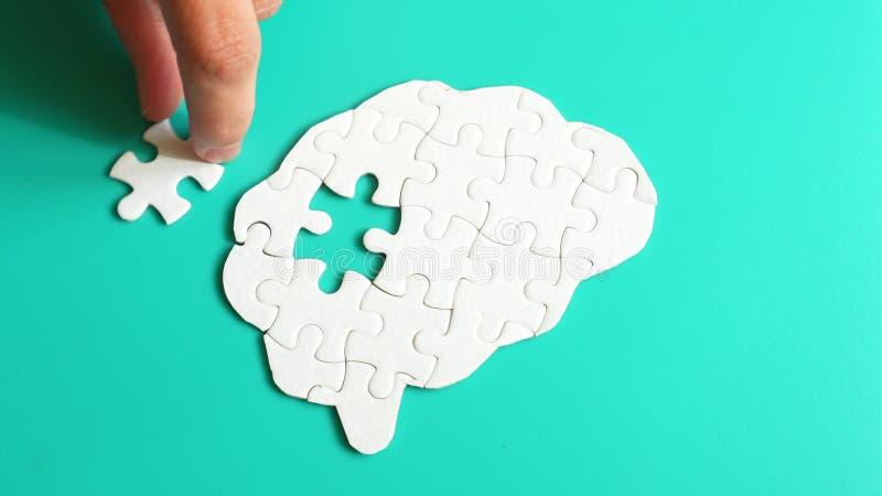 Hand Placing Puzzle Pieces into Brain Shape on Teal Background Stock ...