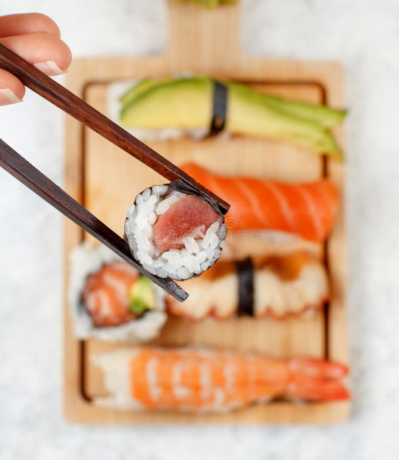 Hand Taking Roll with Chopsticks from a Plate Stock Photo - Image of ...