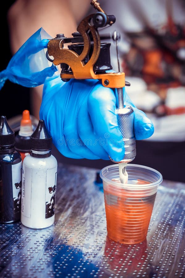 Hand of a Tattoo Artist with a Tattoo Machine. Stock Photo - Image of ...