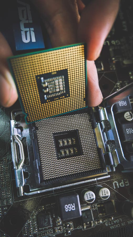 Hand of Technician Operator Assembling the CPU into Computer Mainboard ...