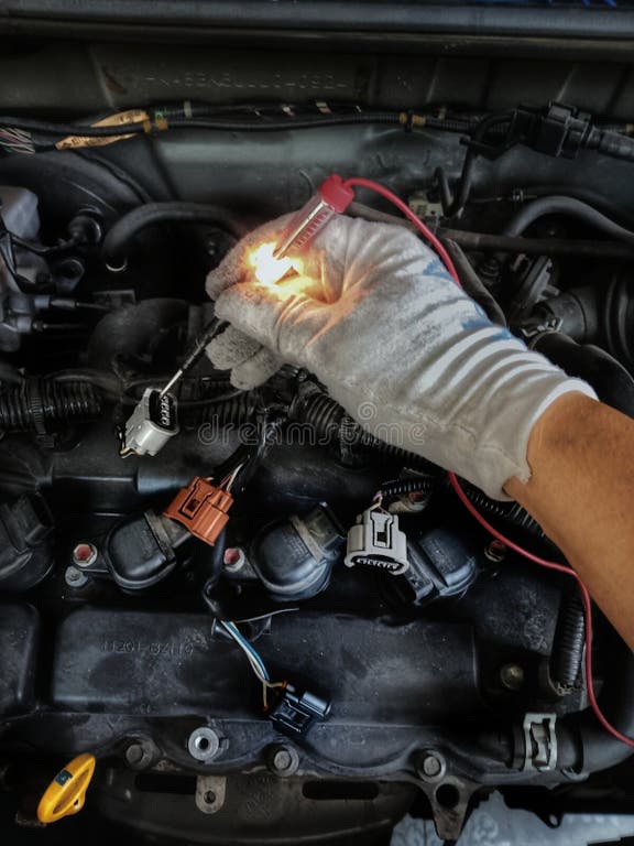 A Hand Testing the Current Present on Ignition Coil Power Socket Stock ...