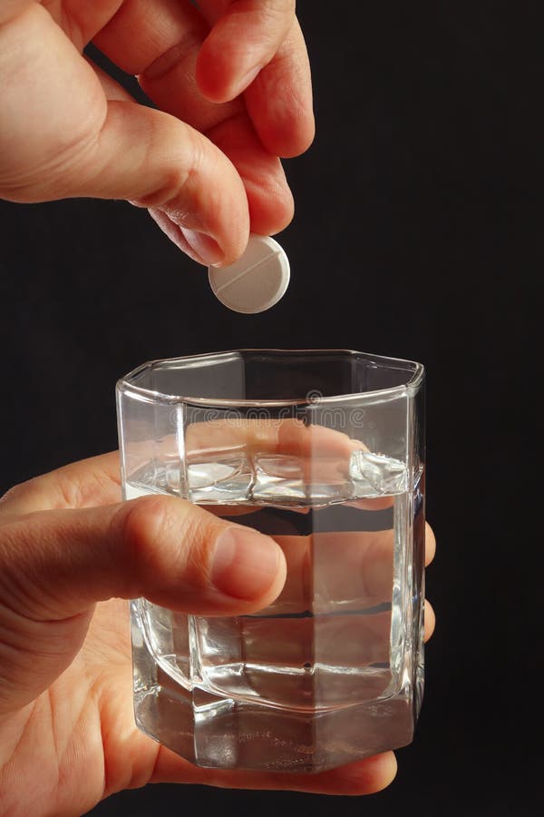 Hand Throwing an Effervescent Tablet from Headache in a Glass of Water ...