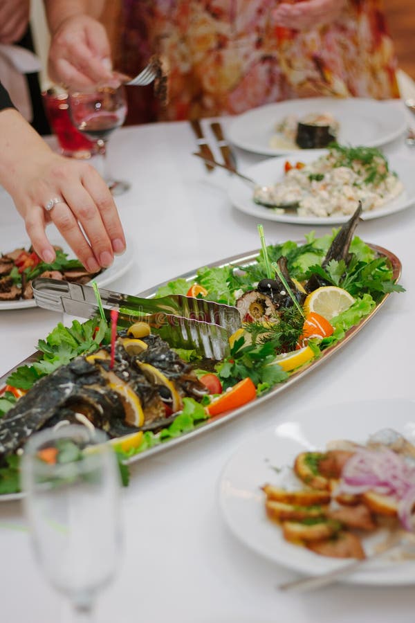 Hand with Tongs Keeping Pieces of Fish during Banquet. Stock Image ...